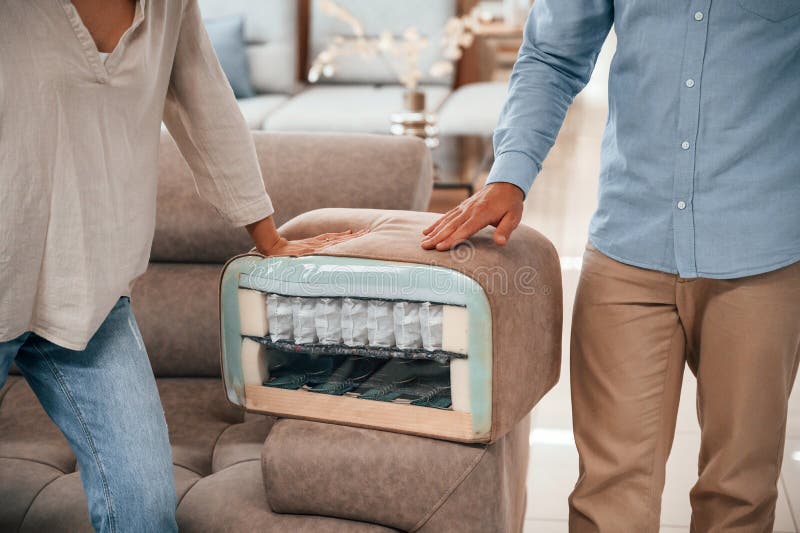 See What`s Inside. Couple Choosing the Sofa and Bed in the Store Stock ...