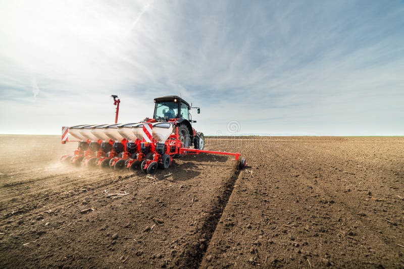 Farmer with Tractor Seeding - Sowing Crops at Agricultural Field Stock ...