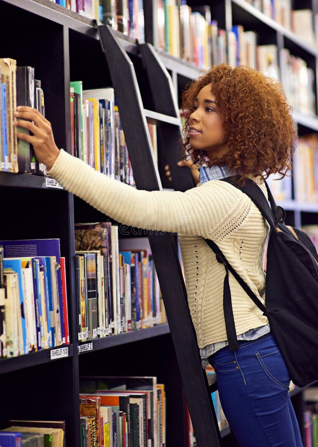 Seeking Knowledge in the Library. a Young Woman Reaching for a Book ...