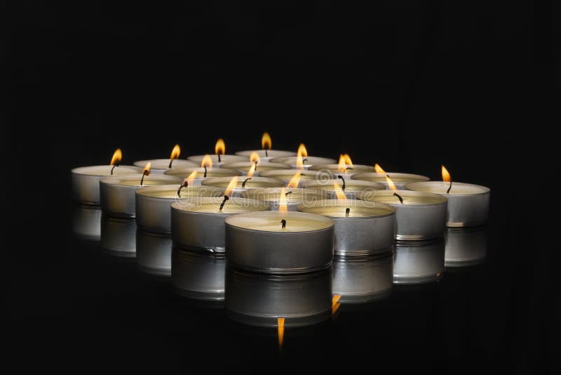 Select Focus of Arranged Lit Tea Light Candles on a Reflective Surface ...