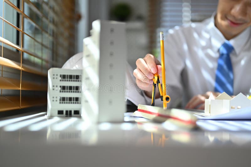 Select Focus on Engineer Hand Compass To Measuring Scale on a Blueprint ...