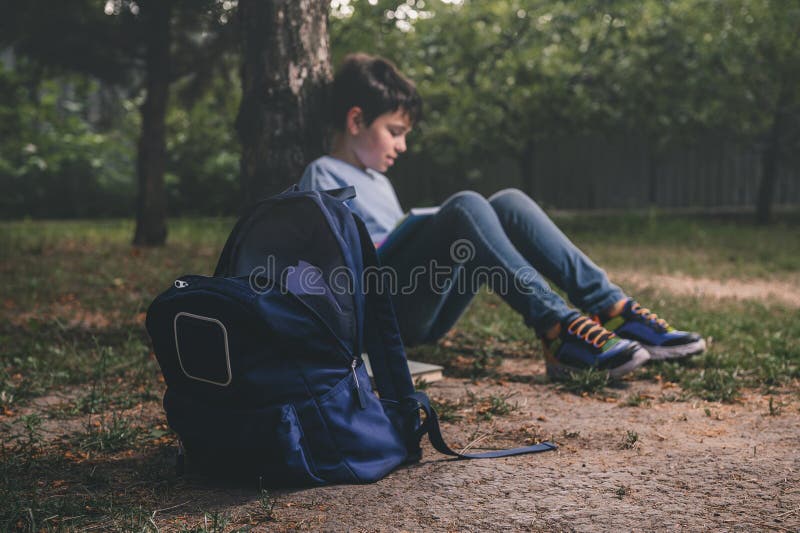 Focus on Backpack Over Smart Teenage Schoolboy Relaxing after Class ...