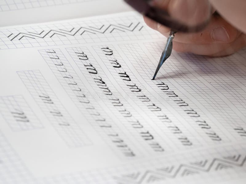 Close-up Pupil`s Hands are Writing Calligraphy in a Notebook. Schoolboy ...