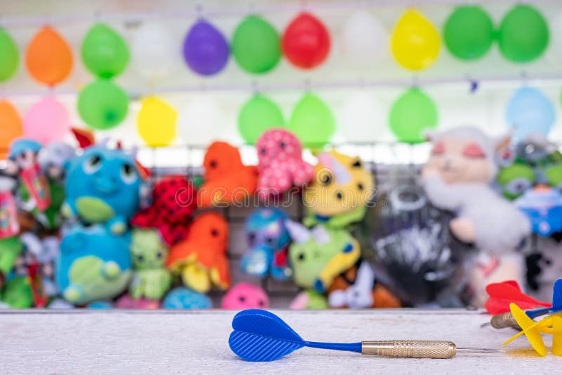 Selective Focus on Darts Sitting on a Ledge with a Wall of Balloon ...