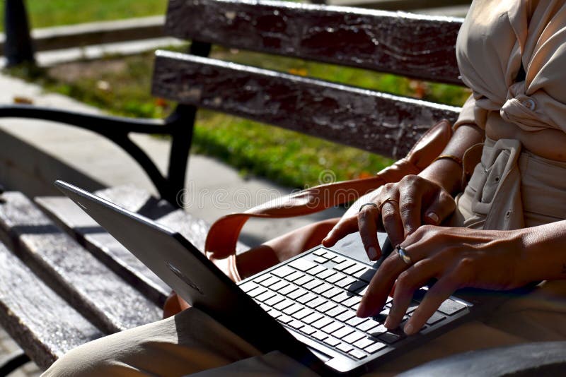 Selective Focus of a Female Person Sitting on a Bench Working on a ...