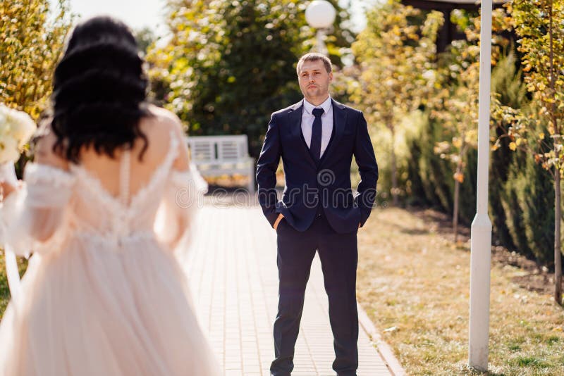 Selective Focus. the Groom Looks at the Bride on a Path in the Park ...