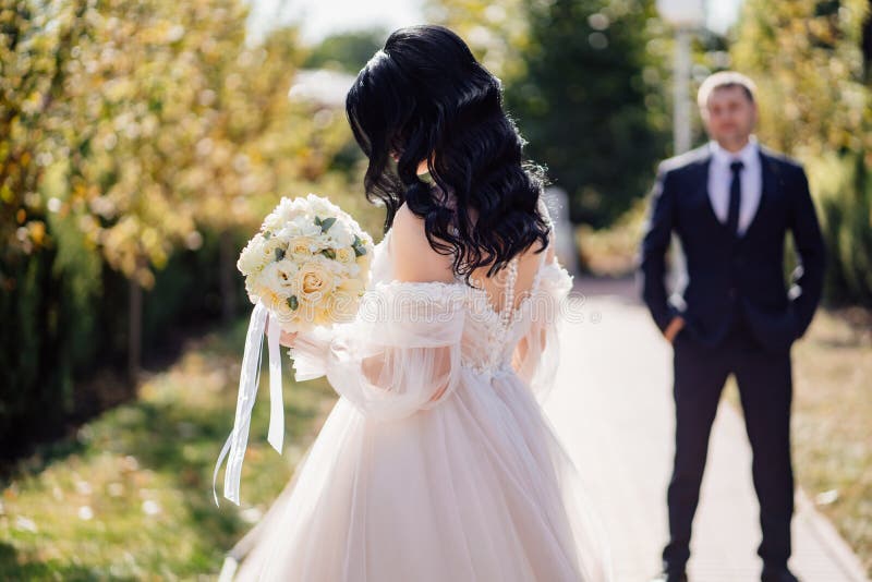 Selective Focus. the Groom Looks at the Bride on a Path in the Park ...