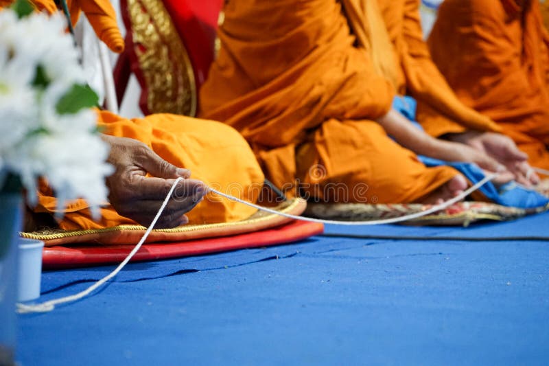 Selective Focus on the Hand of Buddhist Holding the White Rope while ...