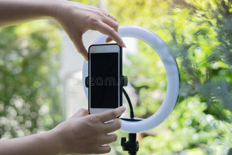 Selective Focus of Hands of Influencer Adjusting Smart Phone on Ring ...
