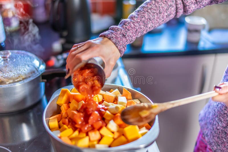 Home Cook Adding a Can of Chopped Tomatoes To a Vegetable Dish Stock ...