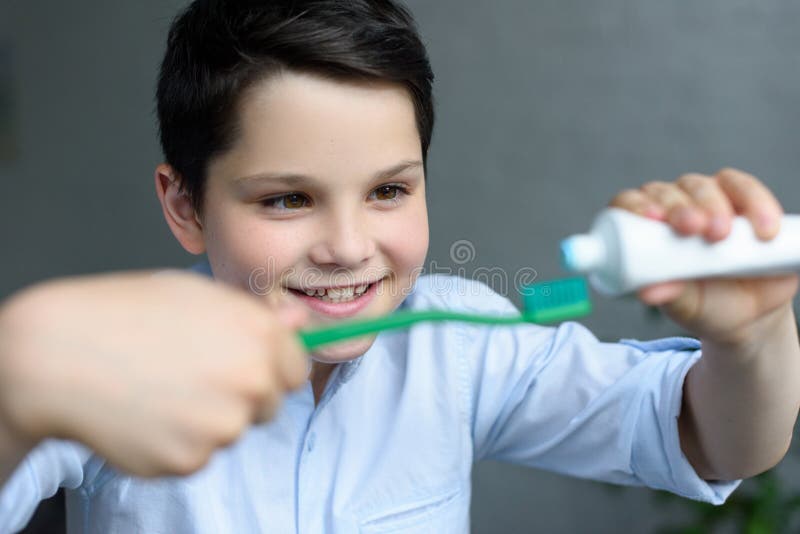 Selective Focus of Little Boy Putting Tooth Paste on Tooth Brush in ...