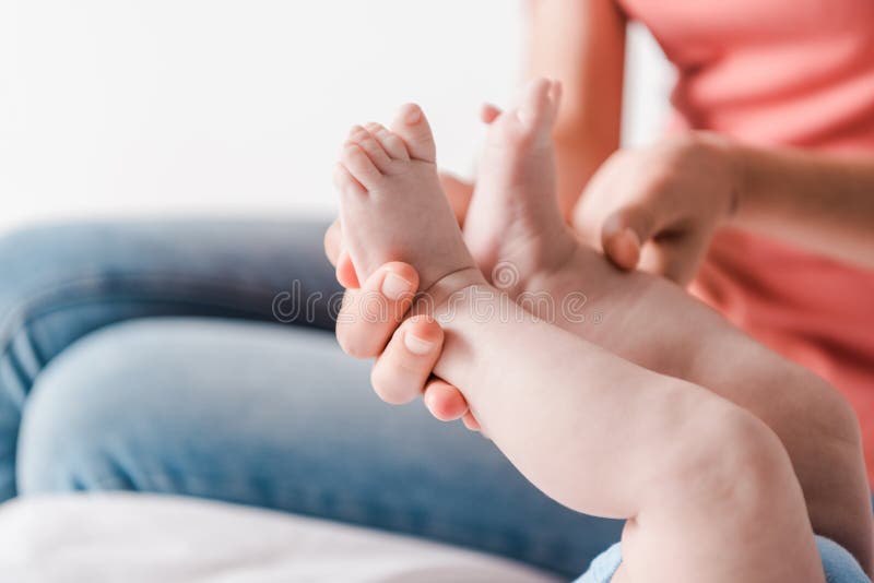 Focus of Mother Touching Legs of Infant Stock Image - Image of cropped ...
