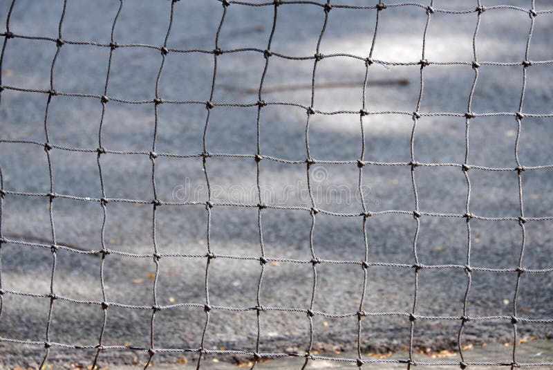 In Selective Focus a Nylon Grid Net with Sunlight and Blurred Concrete ...