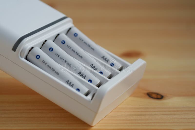 Selective Focus Rechargeable AAA Battery in a White Charger on Wooden ...
