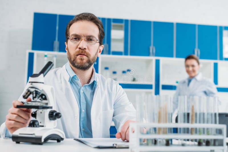 Selective Focus of Scientist in White Coat and Eyeglasses at Workplace ...