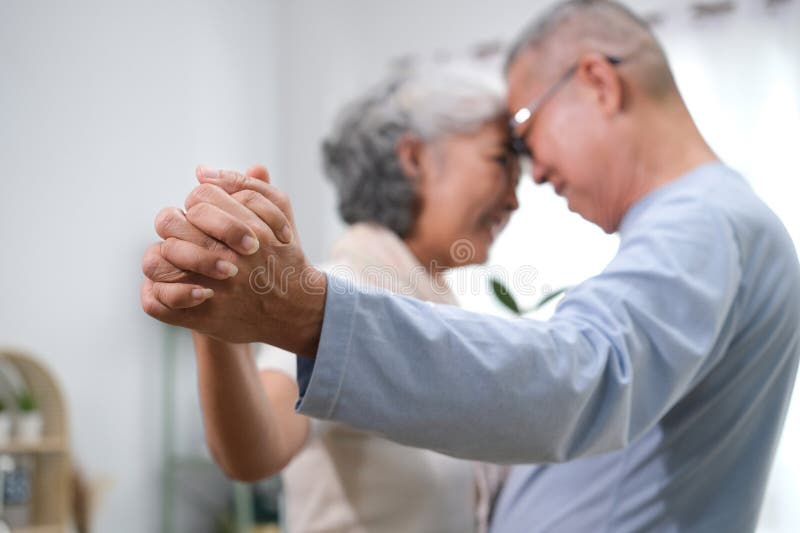 Selective Focus of Senior Couple Holding Hands while Dancing in Living ...