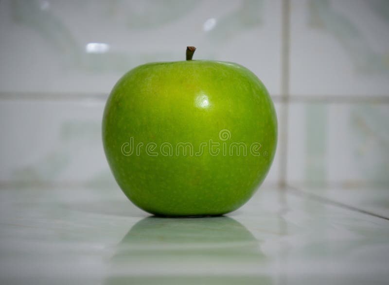 Selective Focus Shot of a Green Apple on a Reflective Surface Stock ...