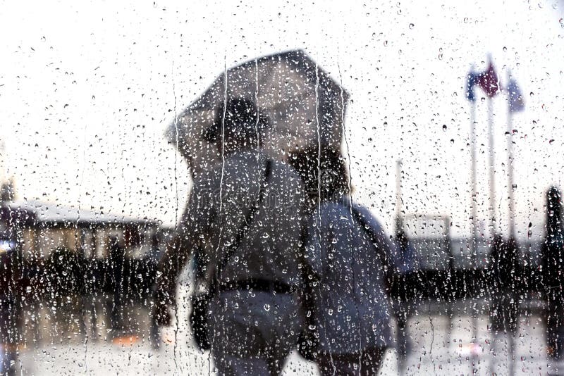 Selective Focus Shot of a Wet Window with a View of a Couple with ...
