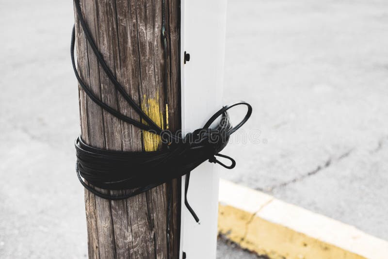Selective Focus Shot of a Wooden Pillar with Black Wire Winded Around ...