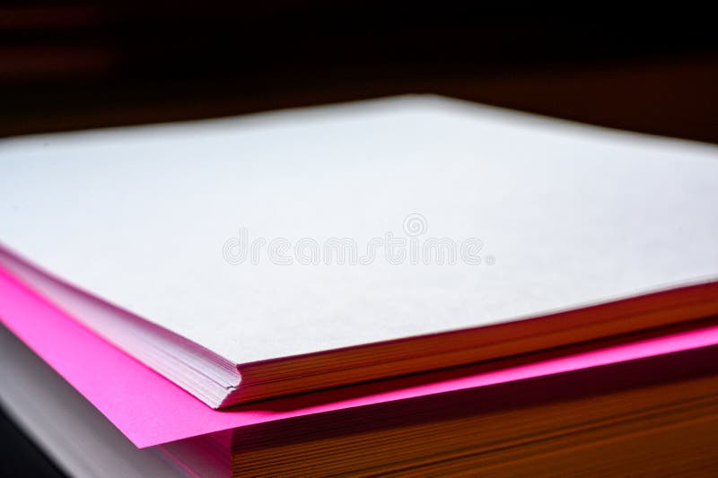Selective Focus on a Single Colored Sheet in a Stack of Plain White ...