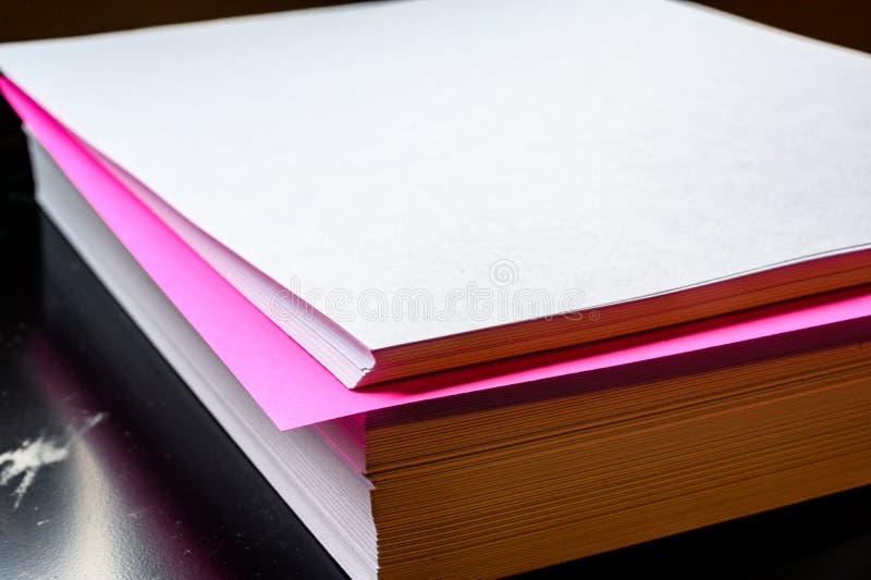 Selective Focus on a Single Colored Sheet in a Stack of Plain White ...