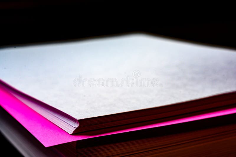 Selective Focus on a Single Colored Sheet in a Stack of Plain White ...