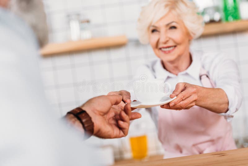 Selective Focus of Smiling Senior Barista Serving Coffee To Visitor ...
