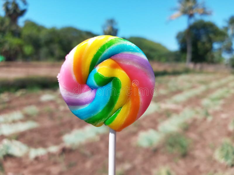 Selective Focus of Swirl Stick Rainbow Candy with Blurred Agriculture ...