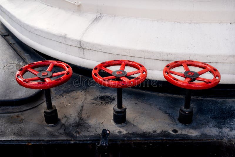Selective Focus on Three Red Painted Iron Wheels on Black Ship Deck ...