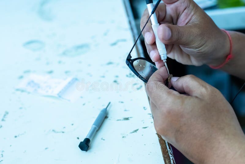 Selective Focus To Hands of an Optician are Using a Screwdriver To ...