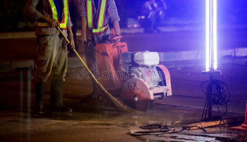 Construction Worker is Working at Night in Construction Site with ...
