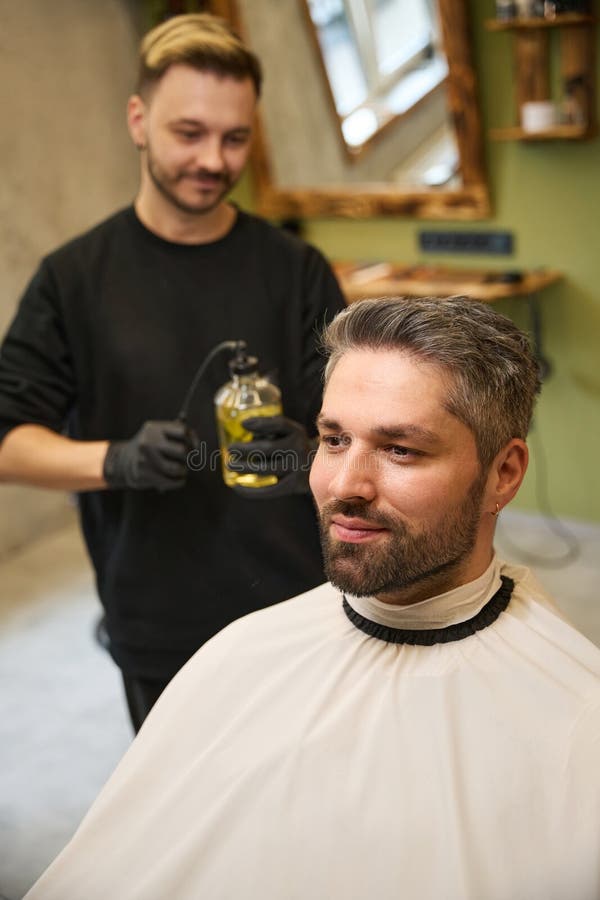 Self-confident Man Sitting at Barber Chair Looking at Reflection in ...