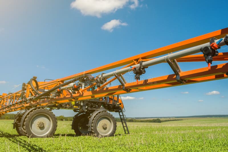 Self-propelled Sprayer Works on a Field Under a Blue Sky with Clouds ...