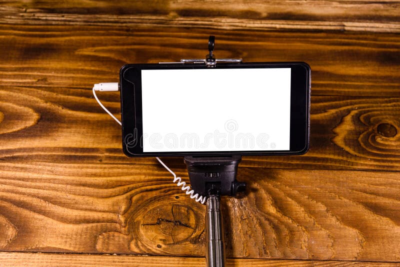 Selfie Stick with Modern Smartphone on a Wooden Table Stock Image ...