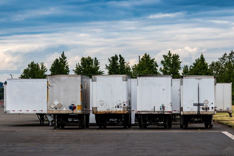 Semi Tractor Trailers Parked in a Row with Doors Closed Under a Blue ...