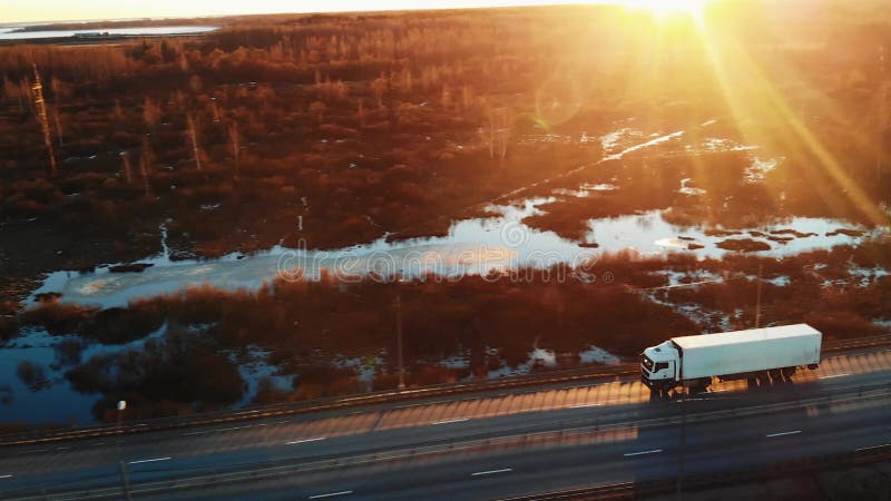 A Semi Truck Driving on a Highway into the Sunset, Front View Aerial ...