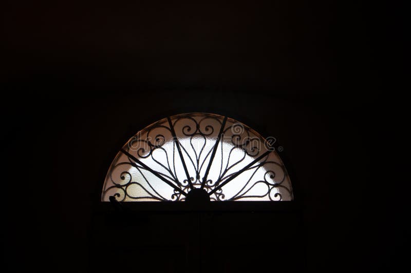 Semicircular Window with a Decorative Grate on a Dark Background Stock ...