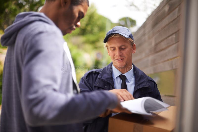 Sending His Things on Their Way. a Handsome Young Man Signing a Form ...