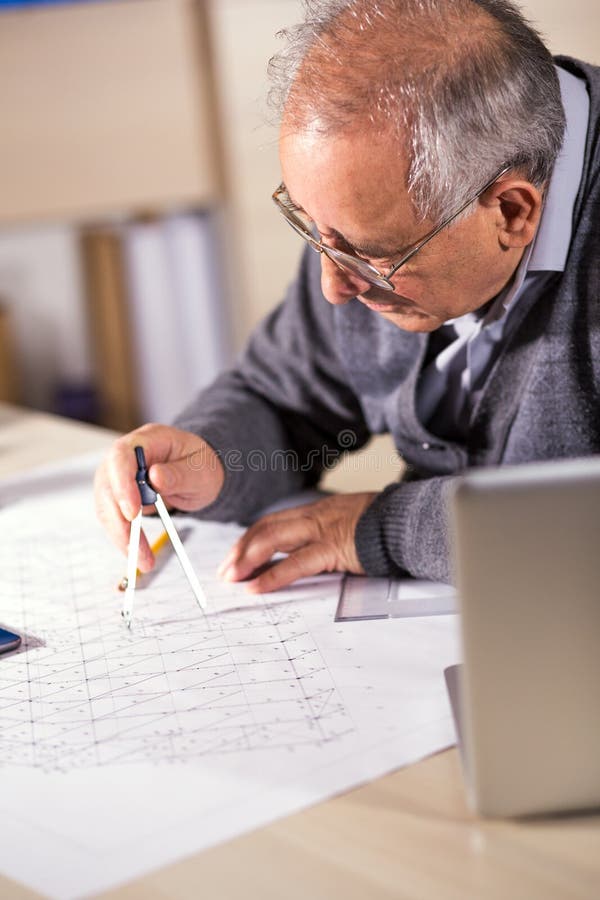 Senior Architect Working on Construction Blueprint in Office Stock ...