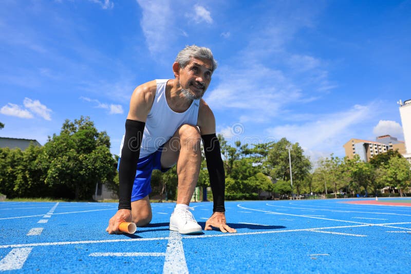Senior Asian Athlete is Practicing Running Block Start in the ...