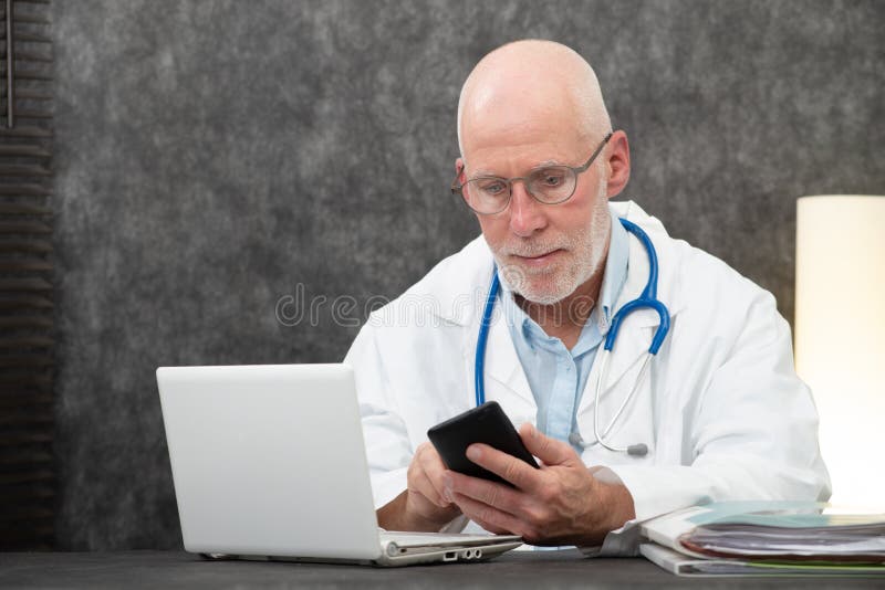 Senior Bearded Doctor Reading Message on Phone Stock Photo - Image of ...
