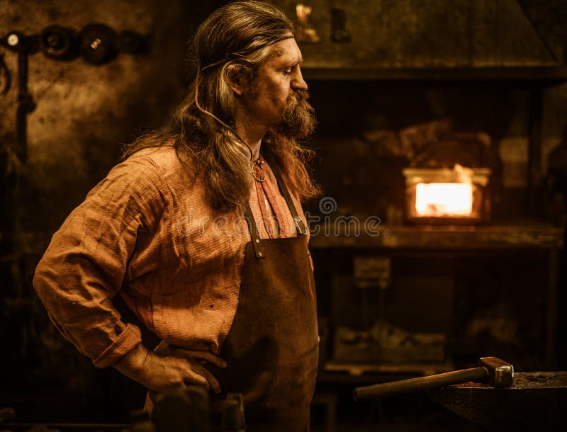 Senior Blacksmith Forging the Molten Metal on the Anvil in Smithy Stock ...