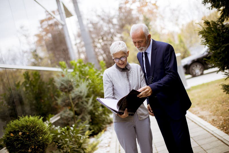 Senior Business People Talking Outdoors and Discussing a Documen Stock ...