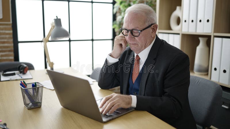 Senior Business Worker Working with Laptop Speaking on the Phone at ...