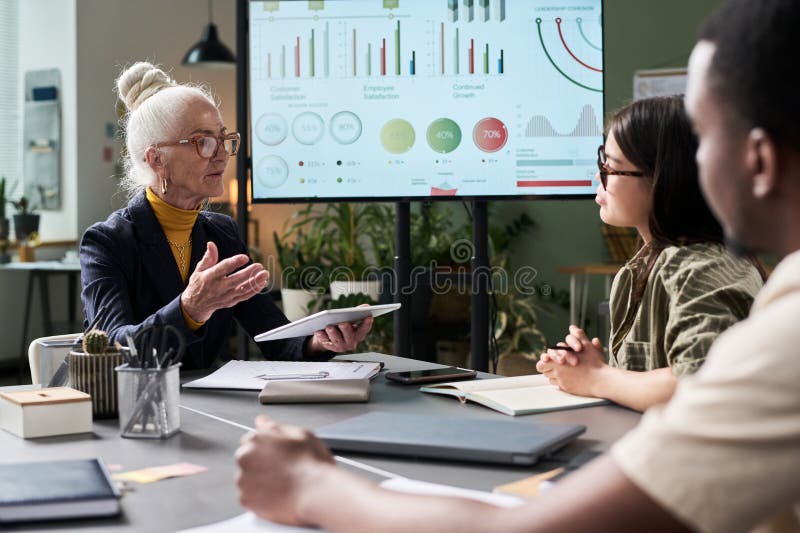 Senior Businesswoman Presenting Data To Diverse Team Stock Photo ...