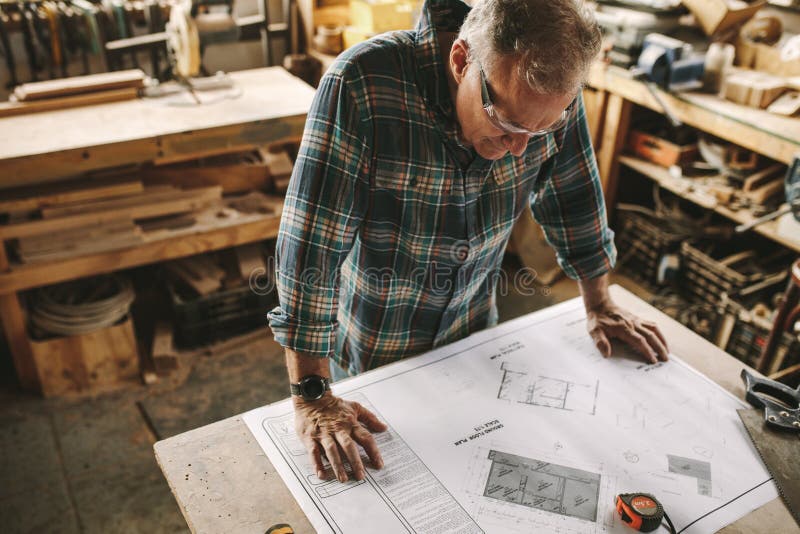 Carpenter with Blueprint in Workshop Stock Photo - Image of floorplan ...