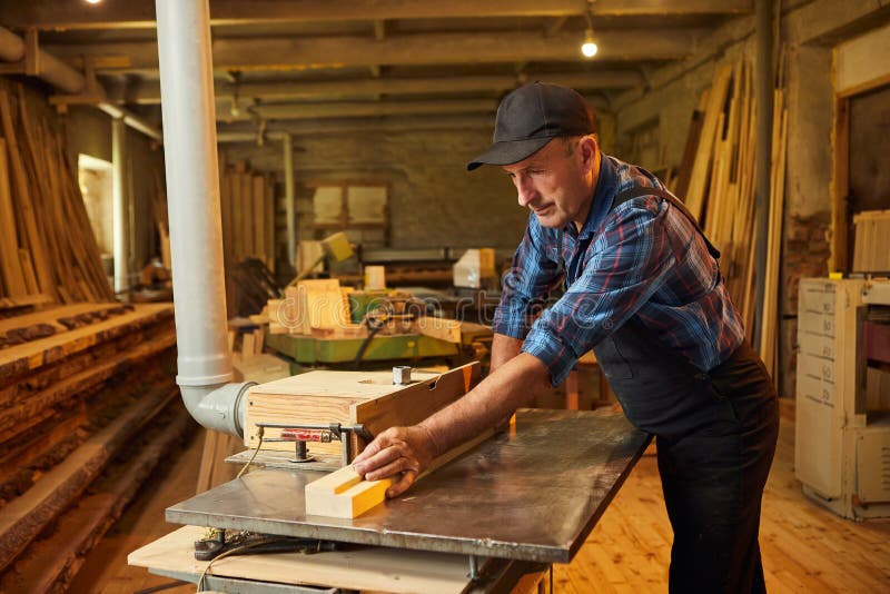 Senior Carpenter in Uniform Works on a Woodworking Machine at the ...