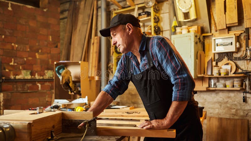 Senior Carpenter in Uniform Works on a Woodworking Machine at the ...