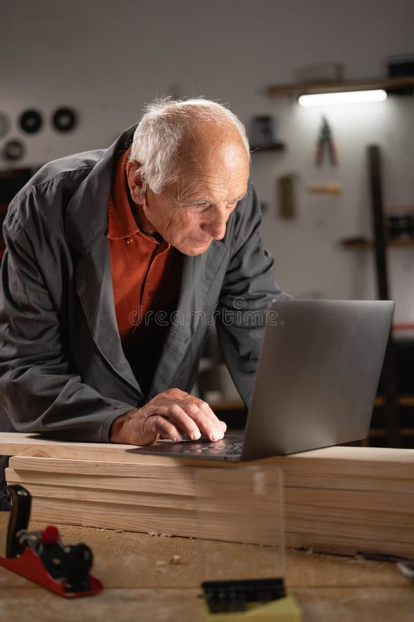 Senior Carpenter Working in Woodwork Workshop Using Laptop Computer and ...