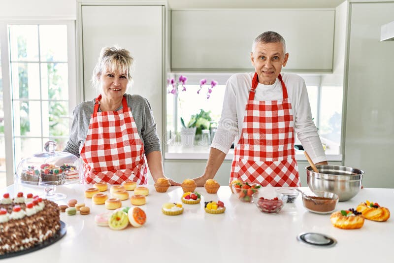 Senior Caucasian Couple Smiling Happy Baking Sweets at the Kitchen ...
